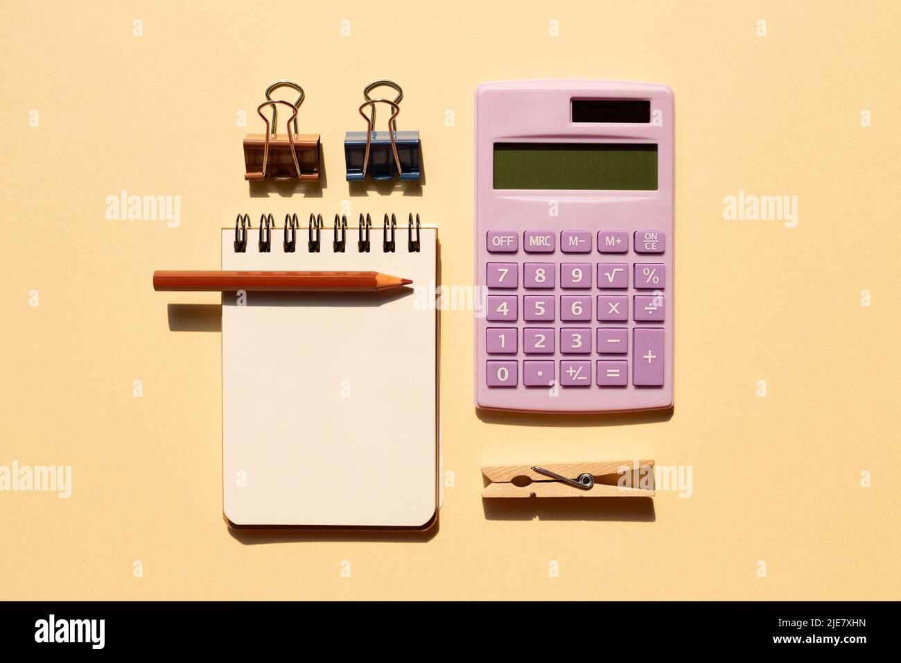 Notepad, colored pencil, calculator on beige background. top view, copy ...