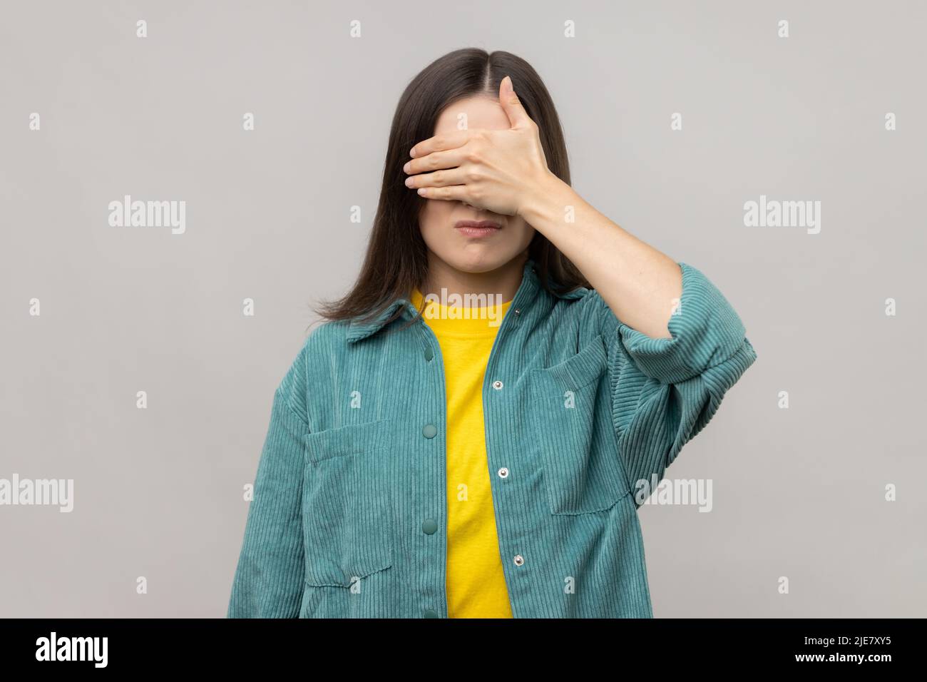 Don't want to look at this. Portrait of shy confused woman covering ...