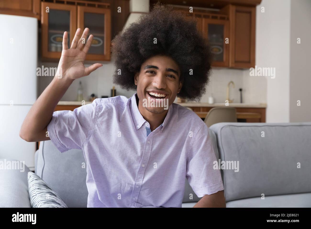 African guy wave hand greets friend start video call Stock Photo - Alamy
