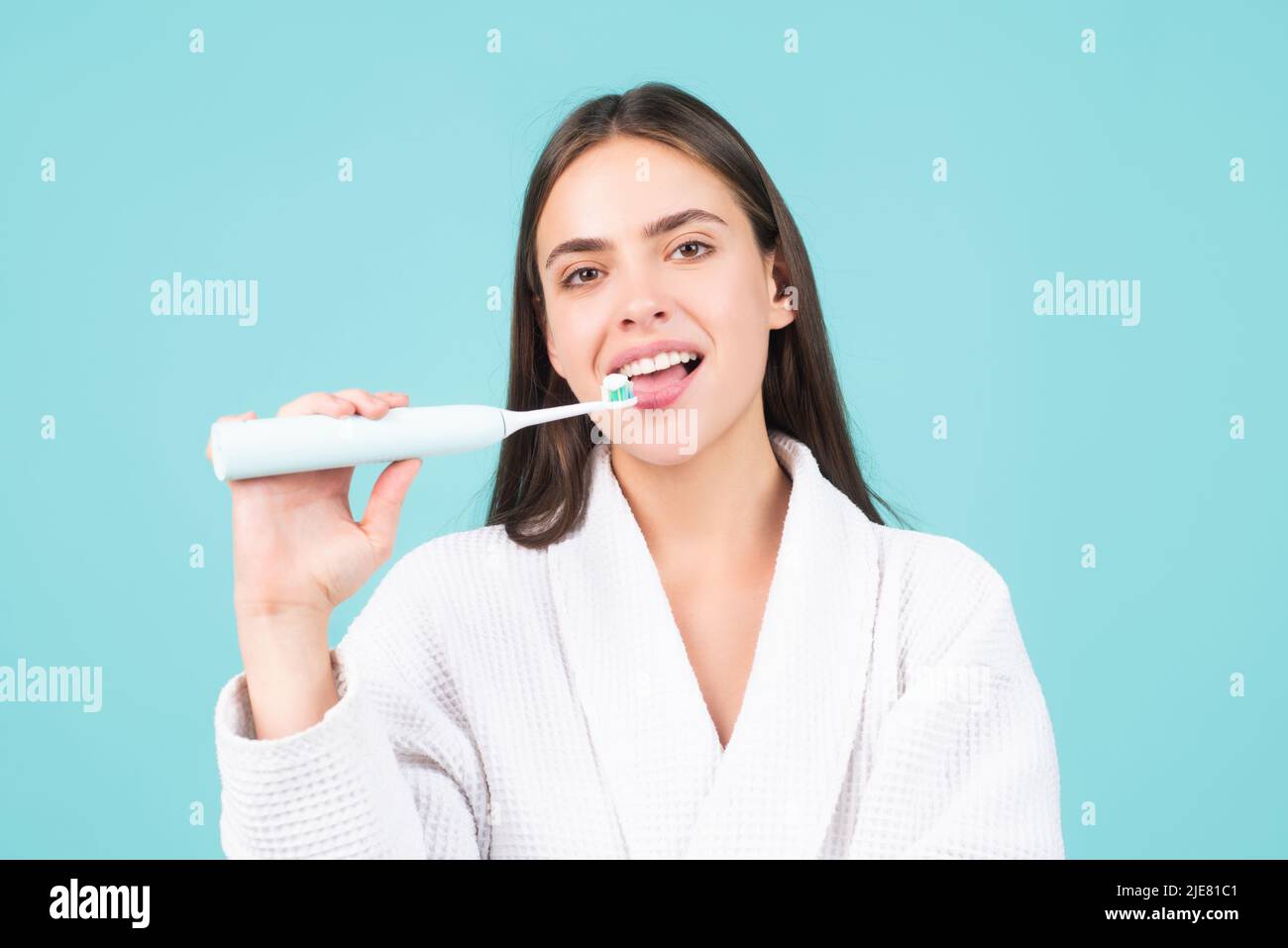 Young cheerful woman brushing teeth with toothbrush during morning ...
