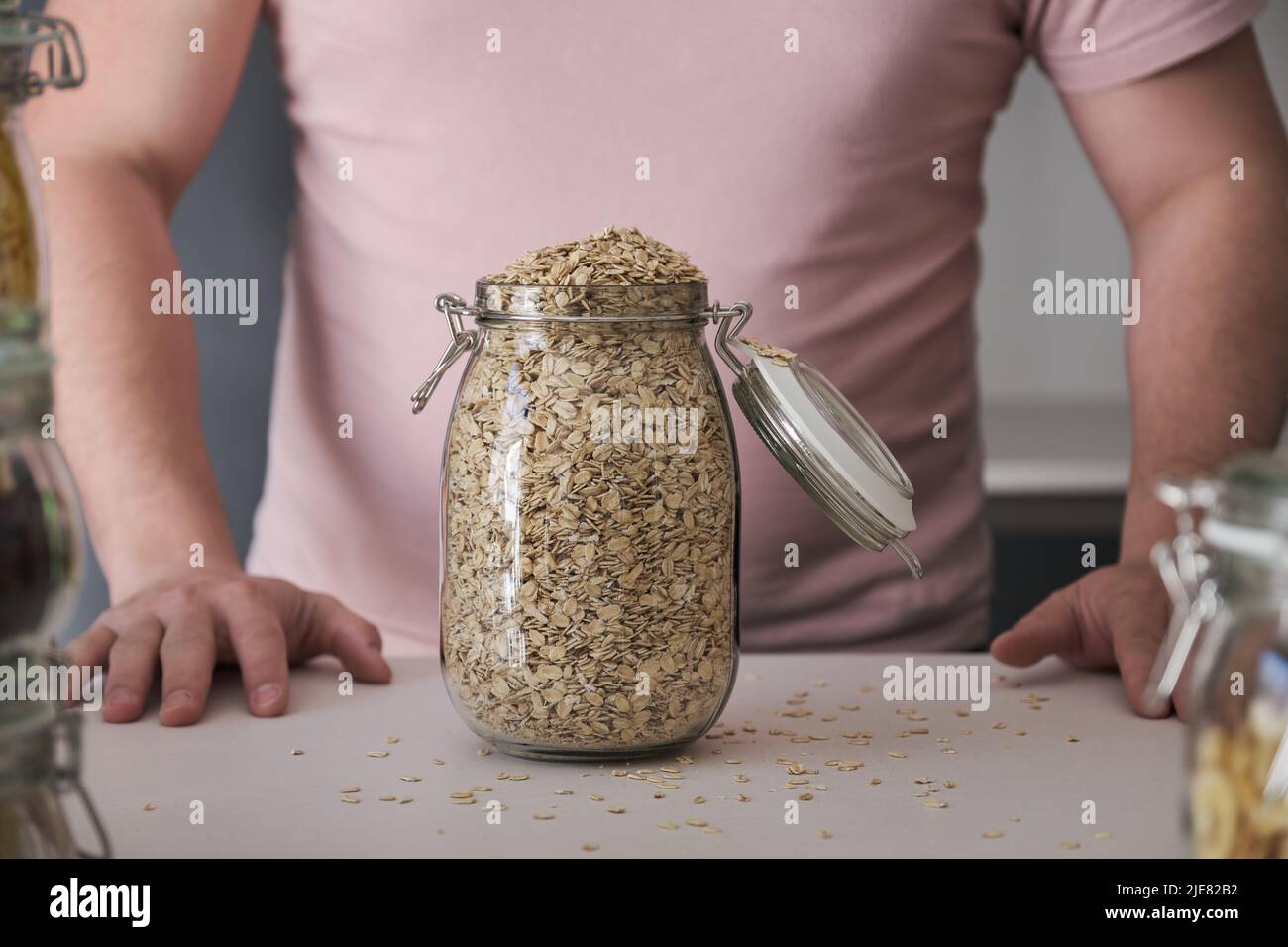 Unrecognizable latin man with a jar full of oat flakes Stock Photo - Alamy
