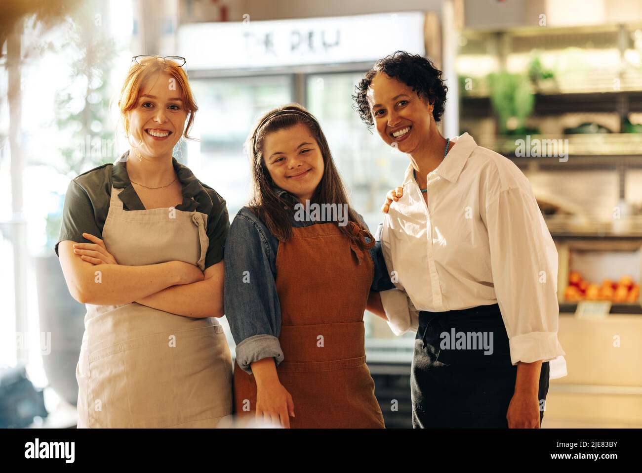 Happy retail workers smiling at the camera while standing together in a ...