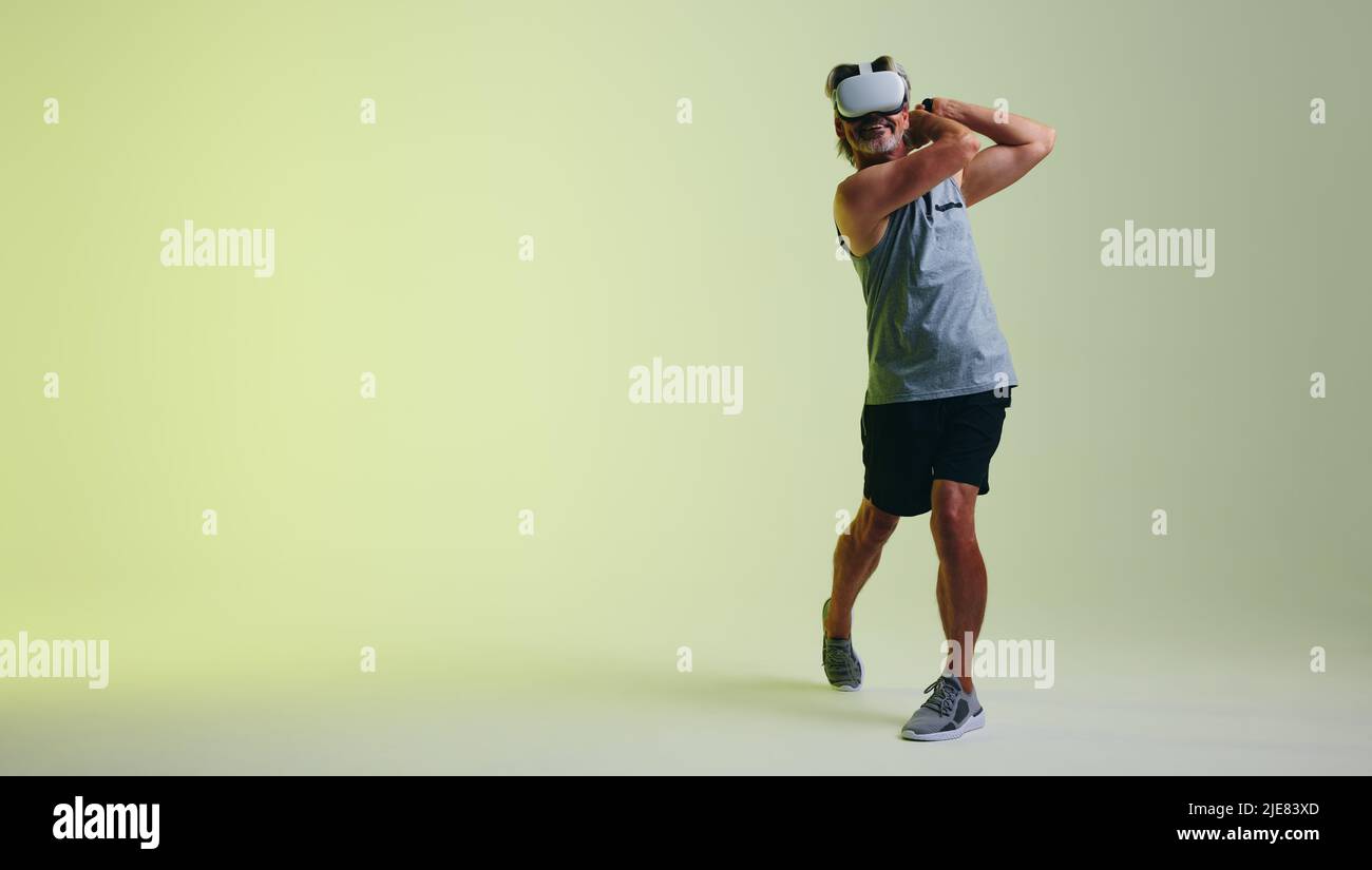 Happy senior man smiling while playing golf in virtual reality. Mature ...
