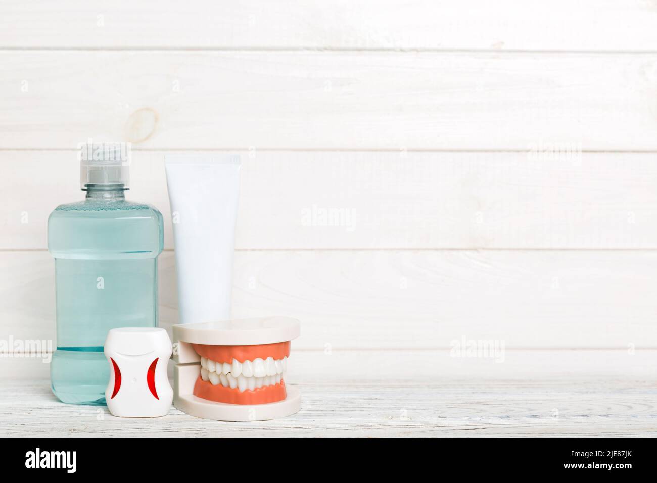 Mouthwash and other oral hygiene products on colored table top view ...