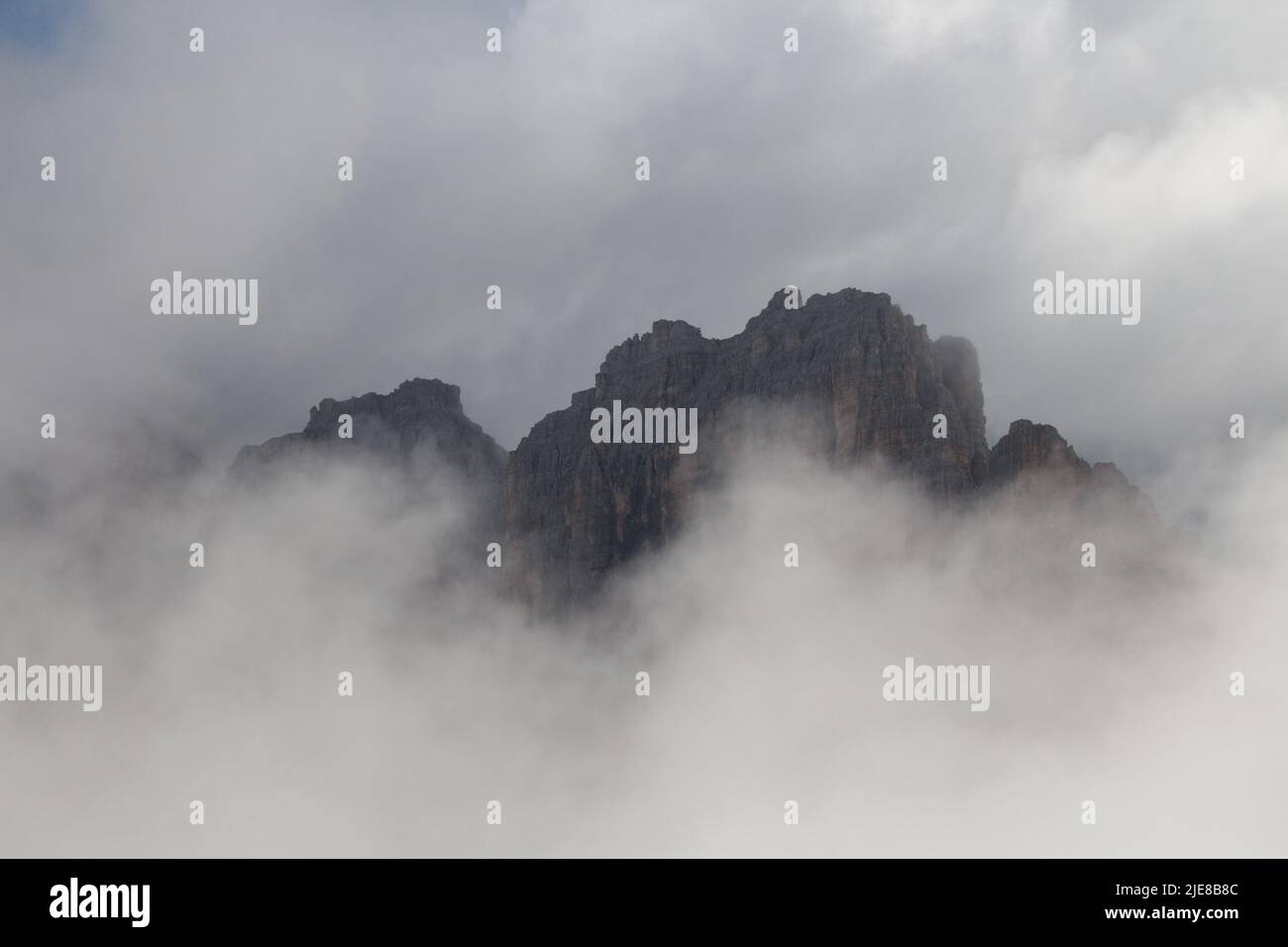 The view of mountain peaks seeing through dense fog, Dolomites, Italian ...