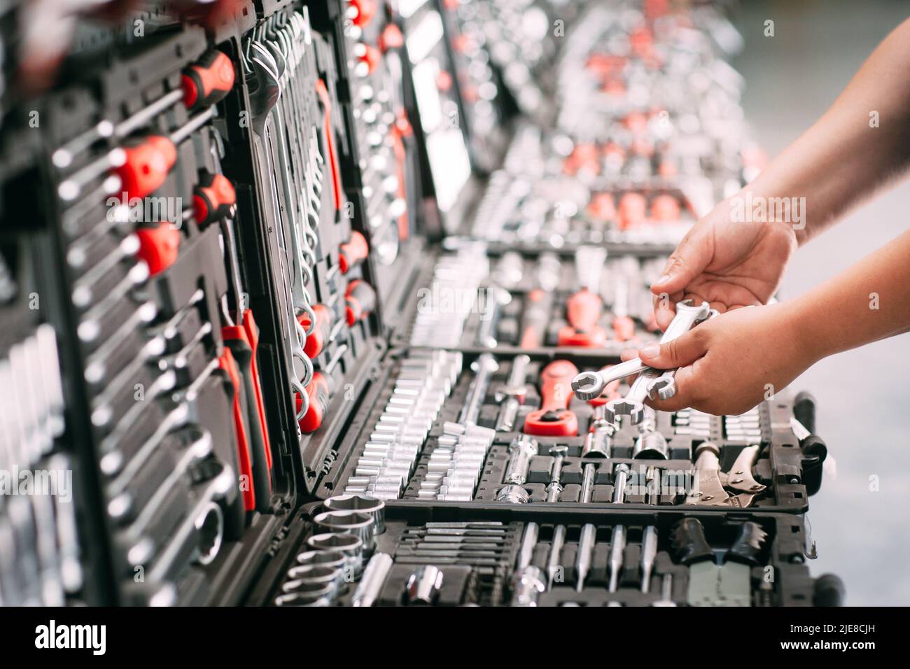 Worker at the store chooses wrench tools Stock Photo - Alamy