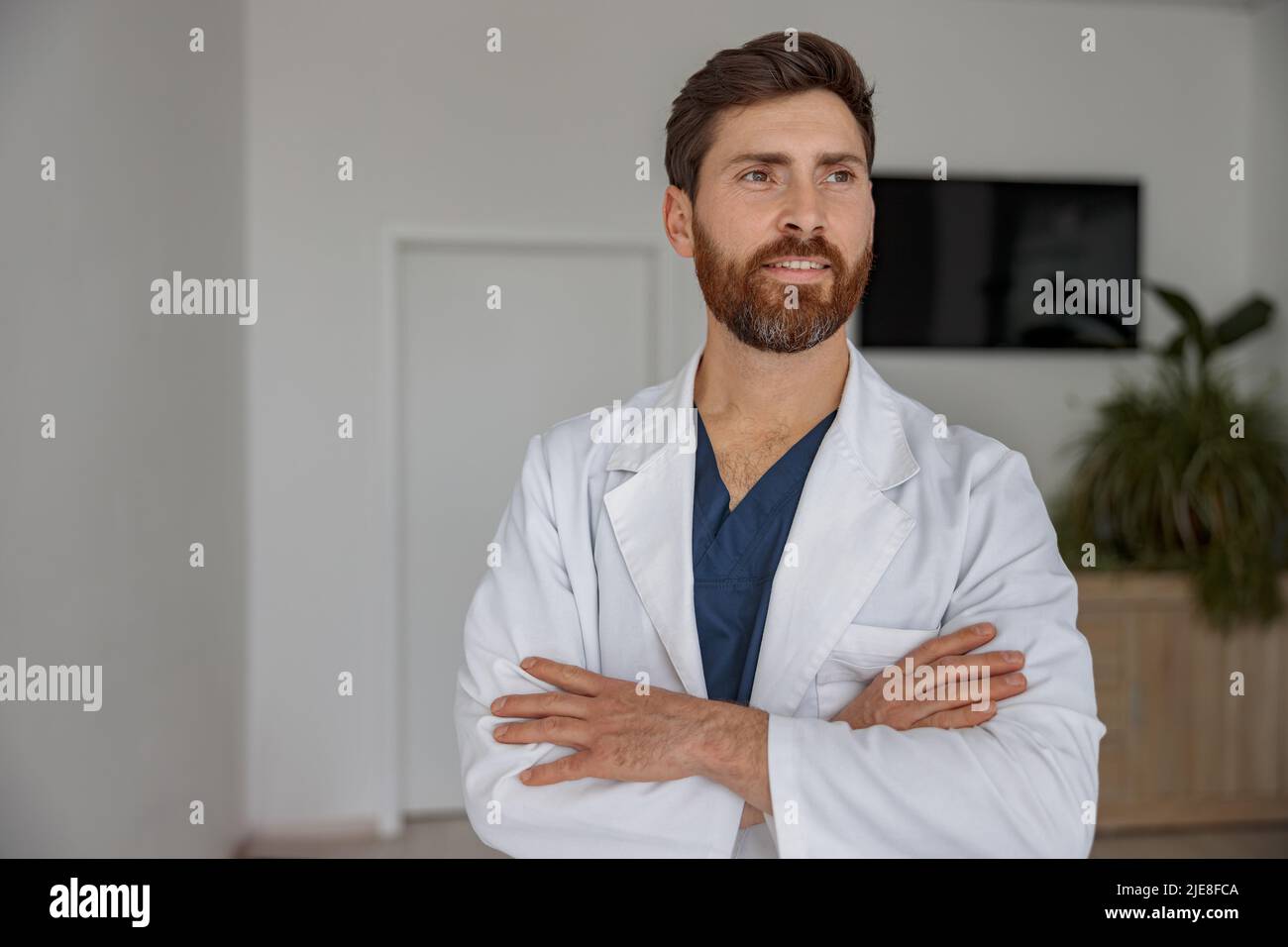 Portrait of handsome doctor in uniform standing in medicine clinic hall ...