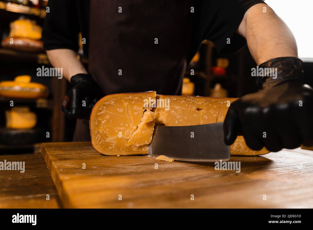 Cheese sommelier cut limited gouda cheese with knife. Snack tasty piece ...