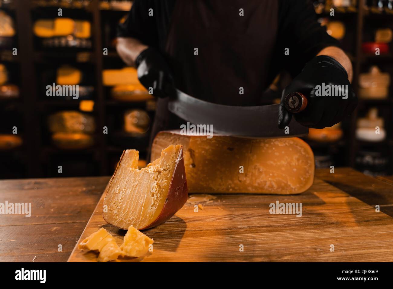 Cheese sommelier cutting limited gouda cheese with knife. Snack tasty ...