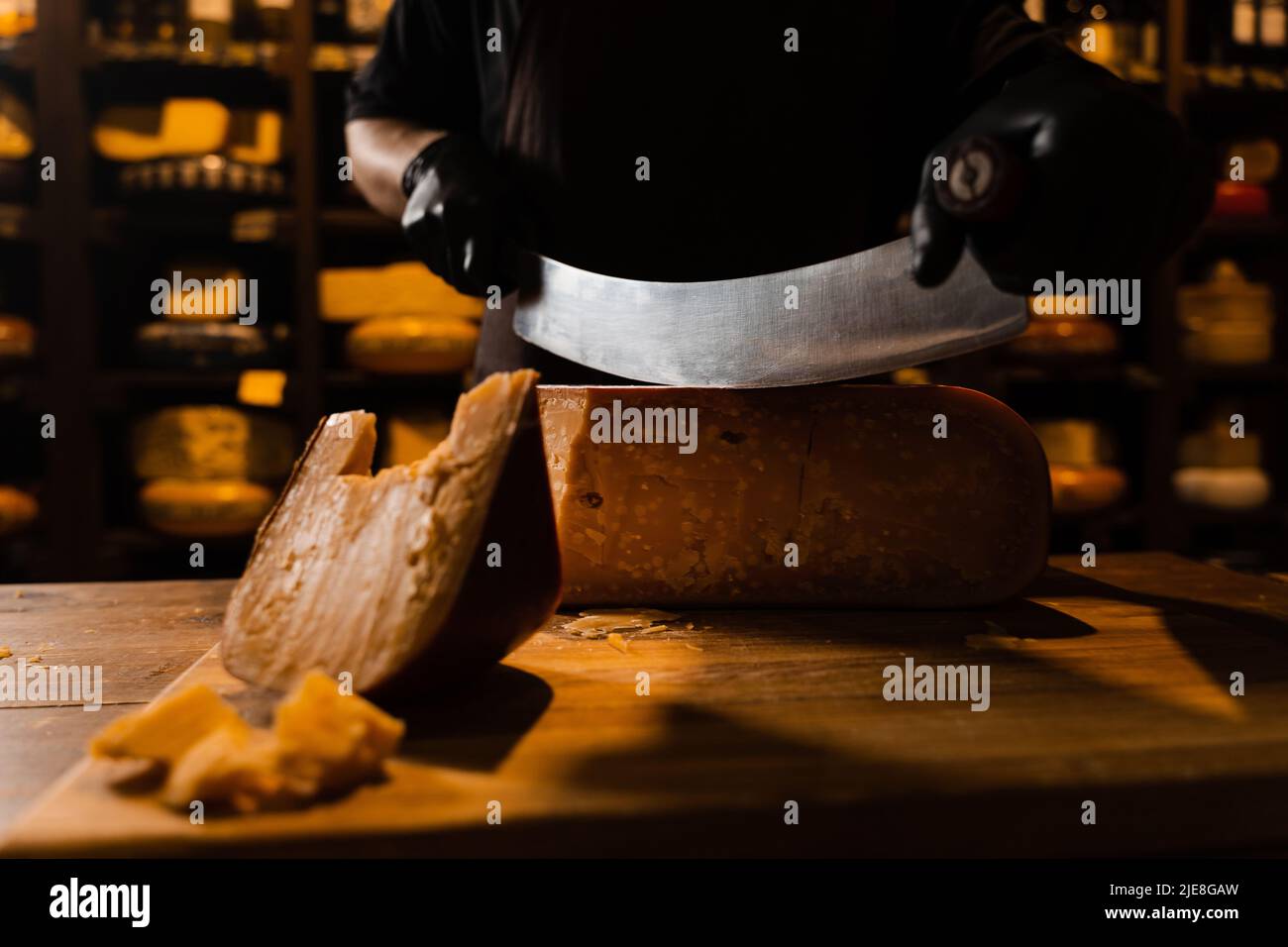 Cheese sommelier cutting limited gouda cheese with knife. Snack tasty ...