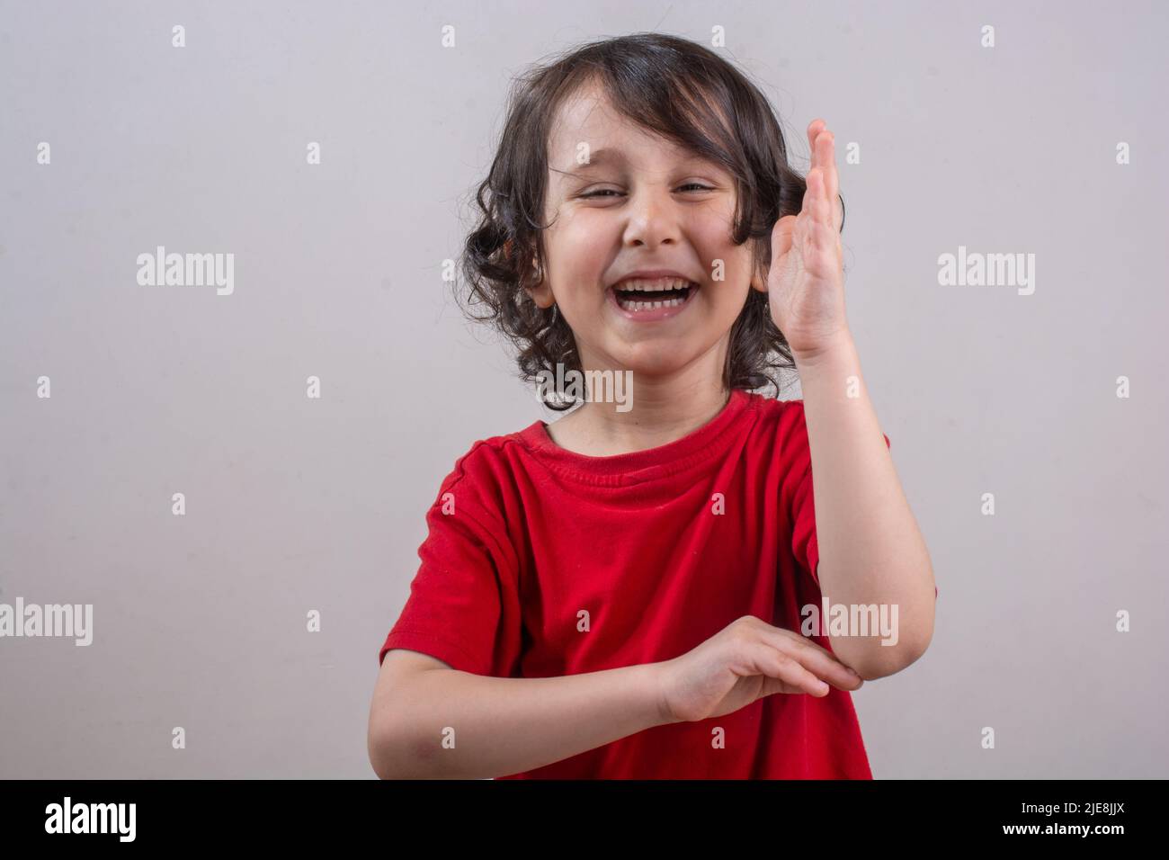 Smiling Little boy raising his hand isolated background Stock Photo - Alamy
