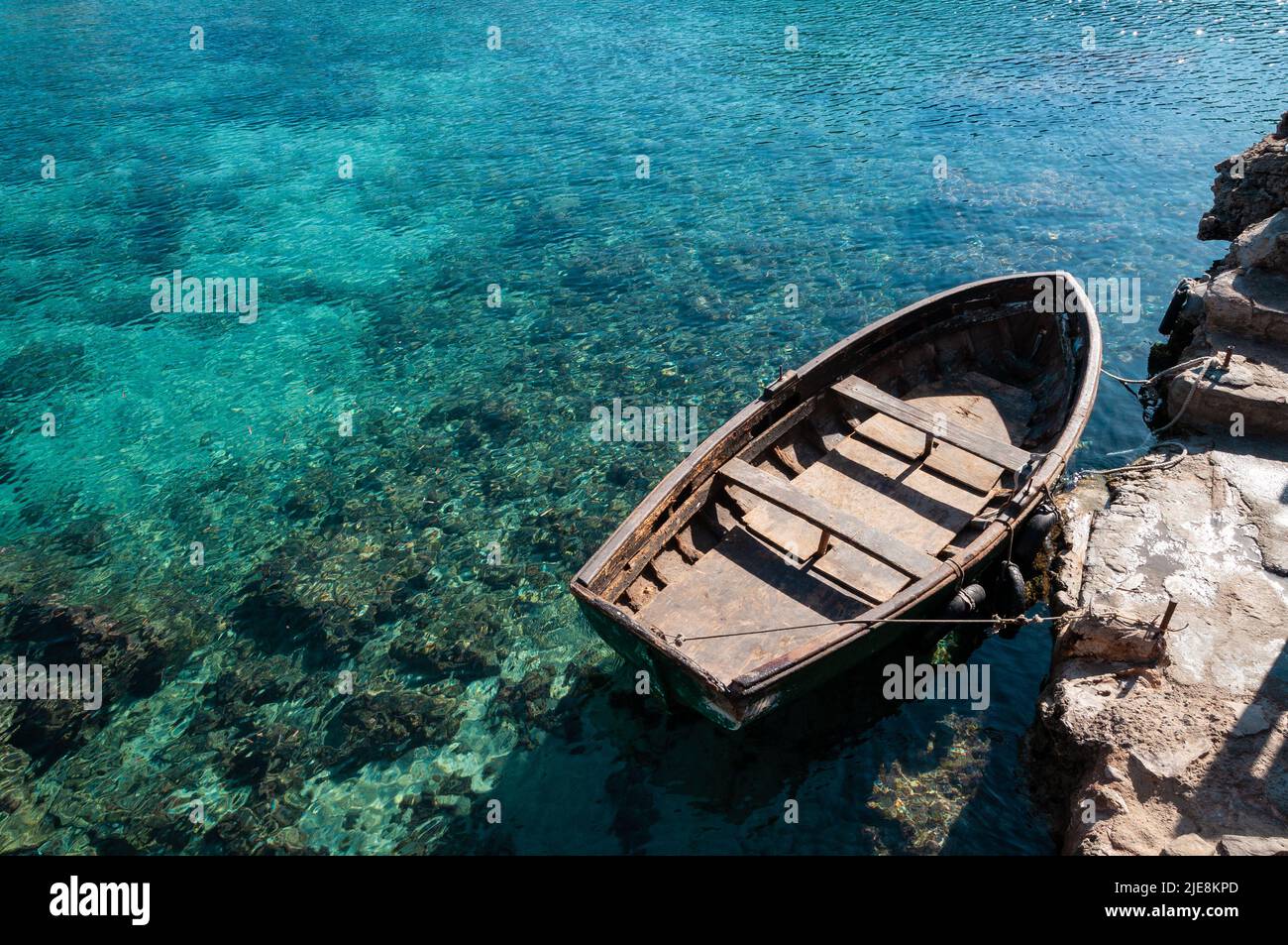 Old rowing boat moored to the rock Stock Photo - Alamy