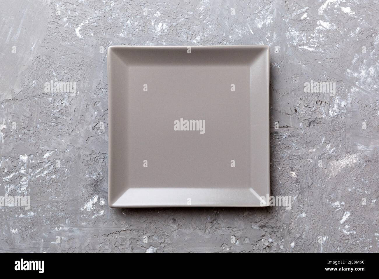 Top view of empty square plate on cement background. Empty space for ...
