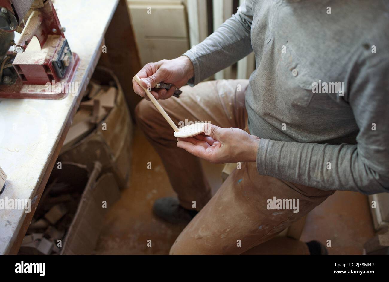 a male craftsman makes children's wooden toys in a carpentry workshop ...