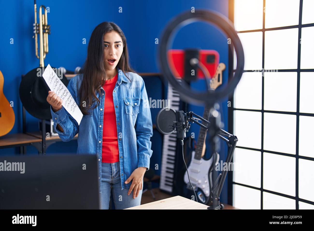 Young teenager girl doing online music tutorial showing music sheet ...