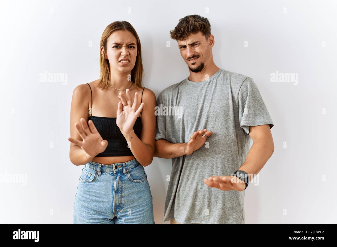 Young beautiful couple standing together over isolated background ...