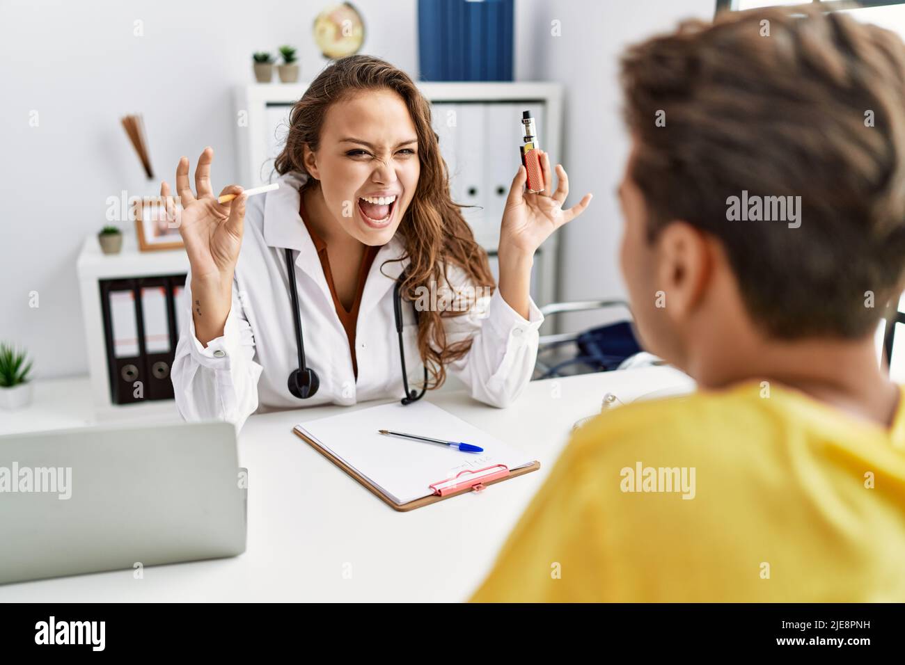 Young doctor woman showing electronic cigarette and normal cigarrete to ...