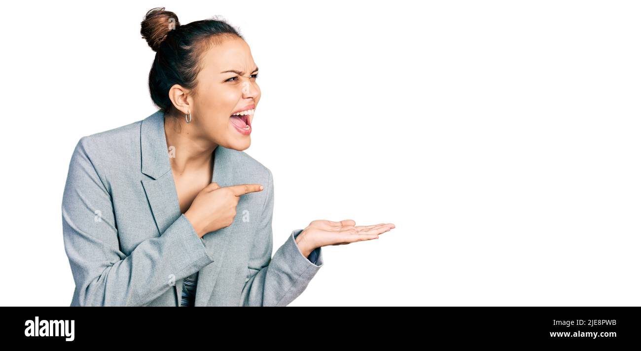 Young hispanic girl pointing open palm with finger angry and mad ...