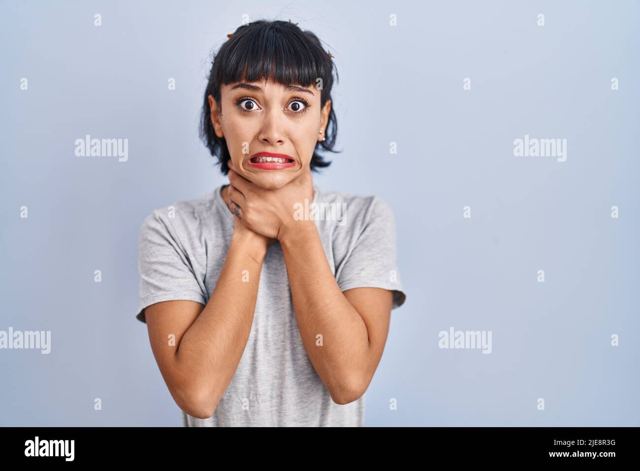 Young hispanic woman wearing casual t shirt over blue background ...