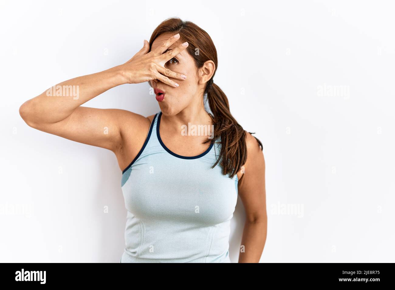 Young latin woman wearing sporty clothes over isolated background ...