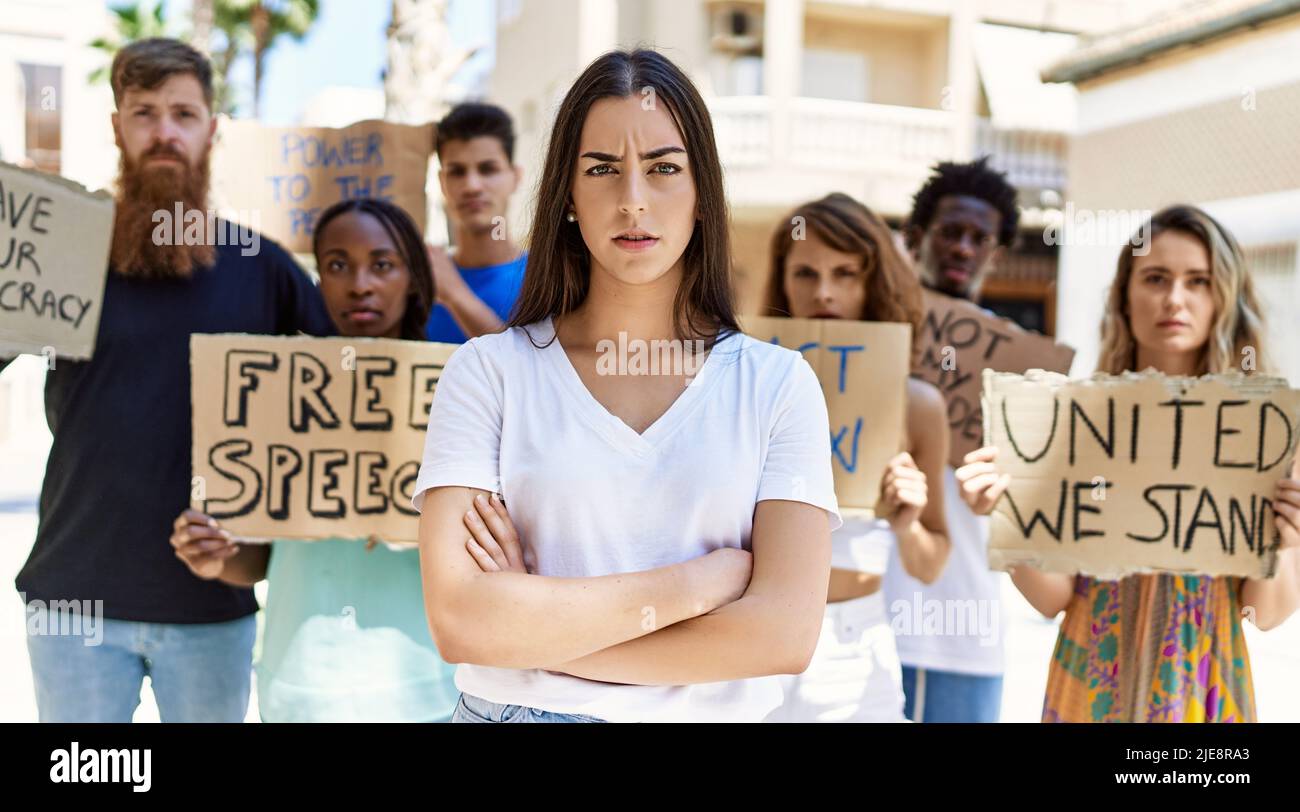 Young activist woman with arms crossed gesture standing with a group of ...