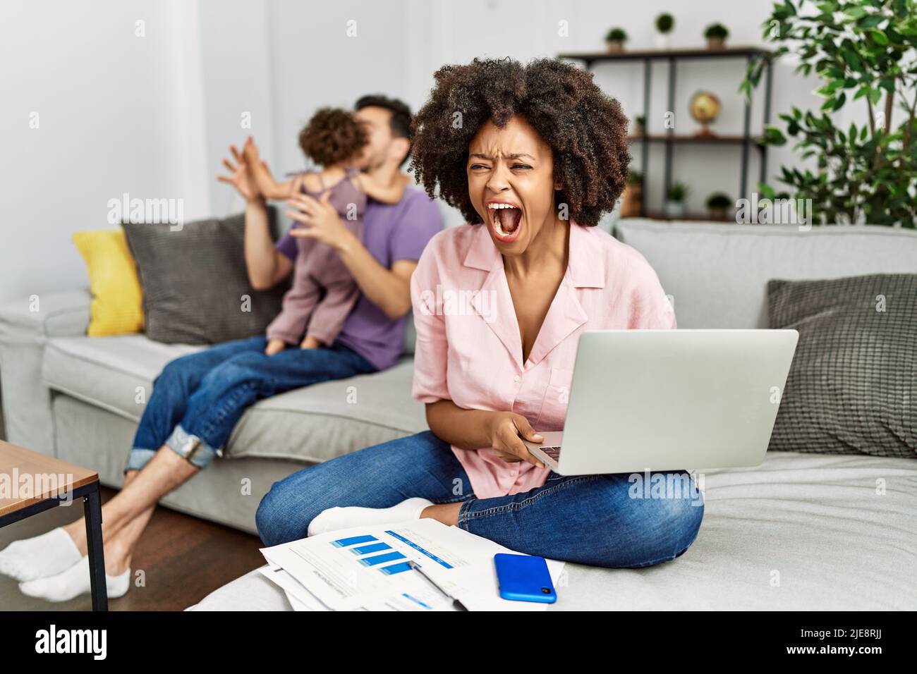 Mother of interracial family working using computer laptop at home ...