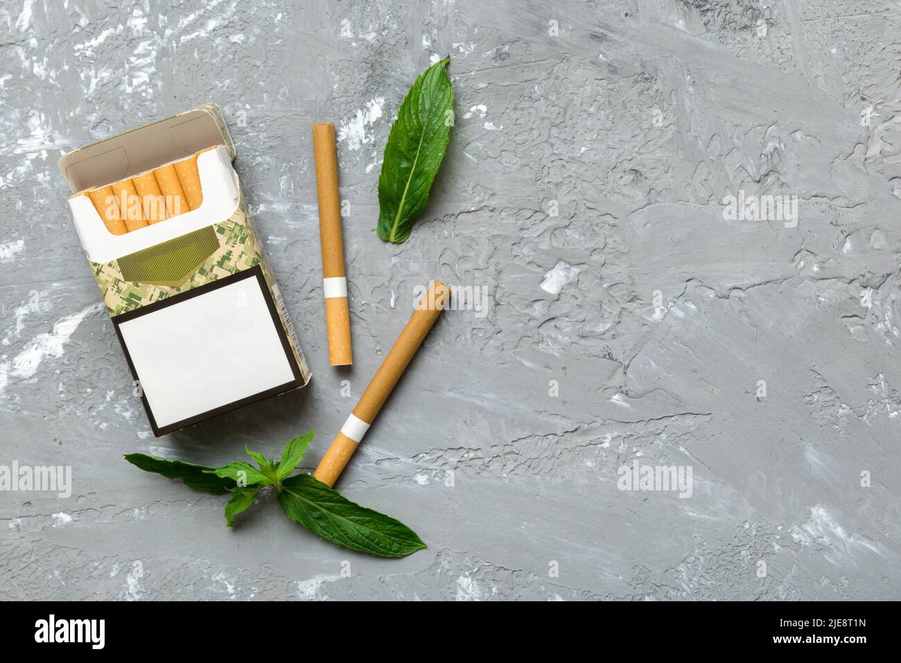 Pack of menthol cigarettes and fresh mint on colored table, Menthol ...