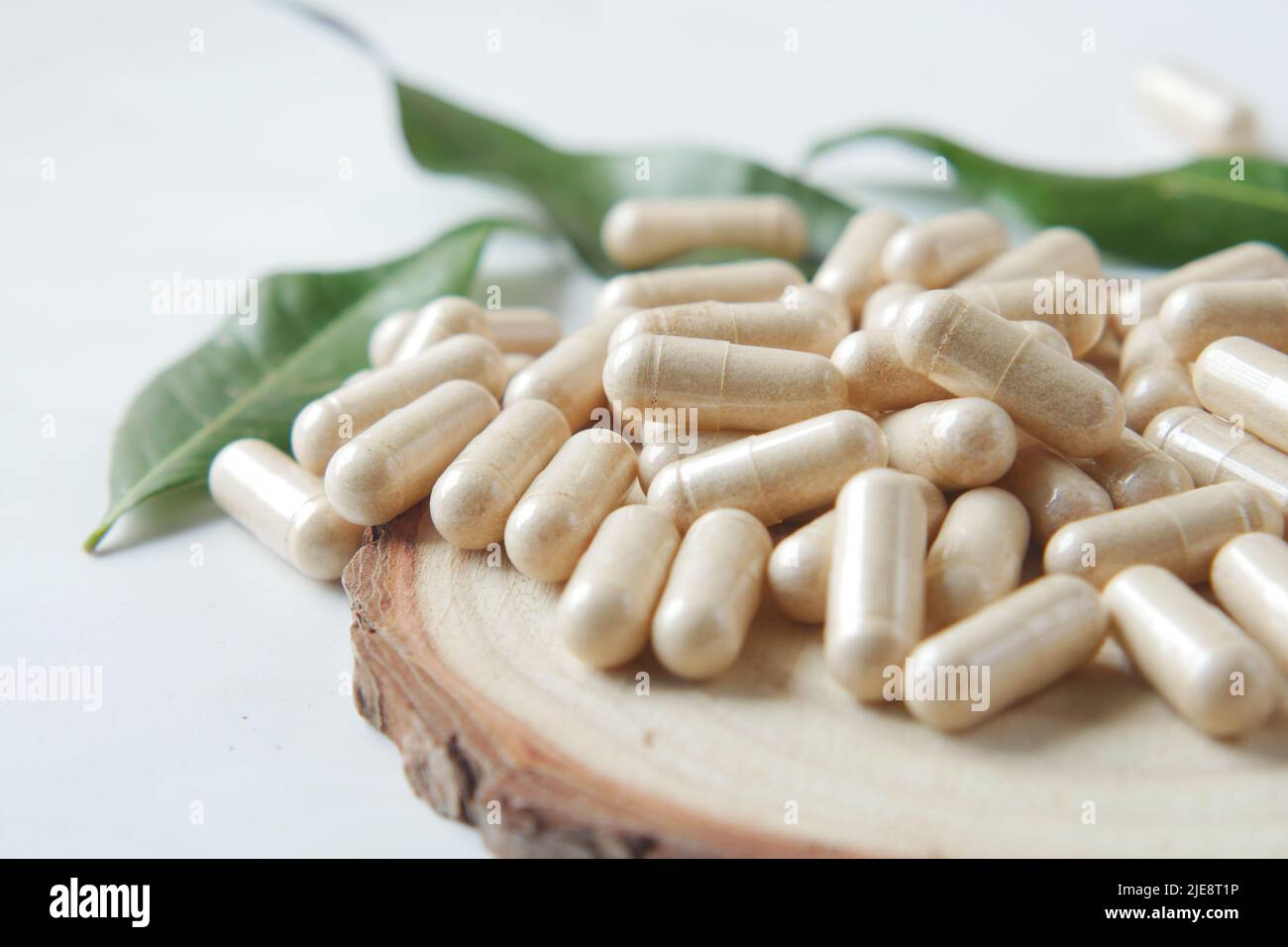 top view of herbal medicine capsule dropping on white Stock Photo - Alamy