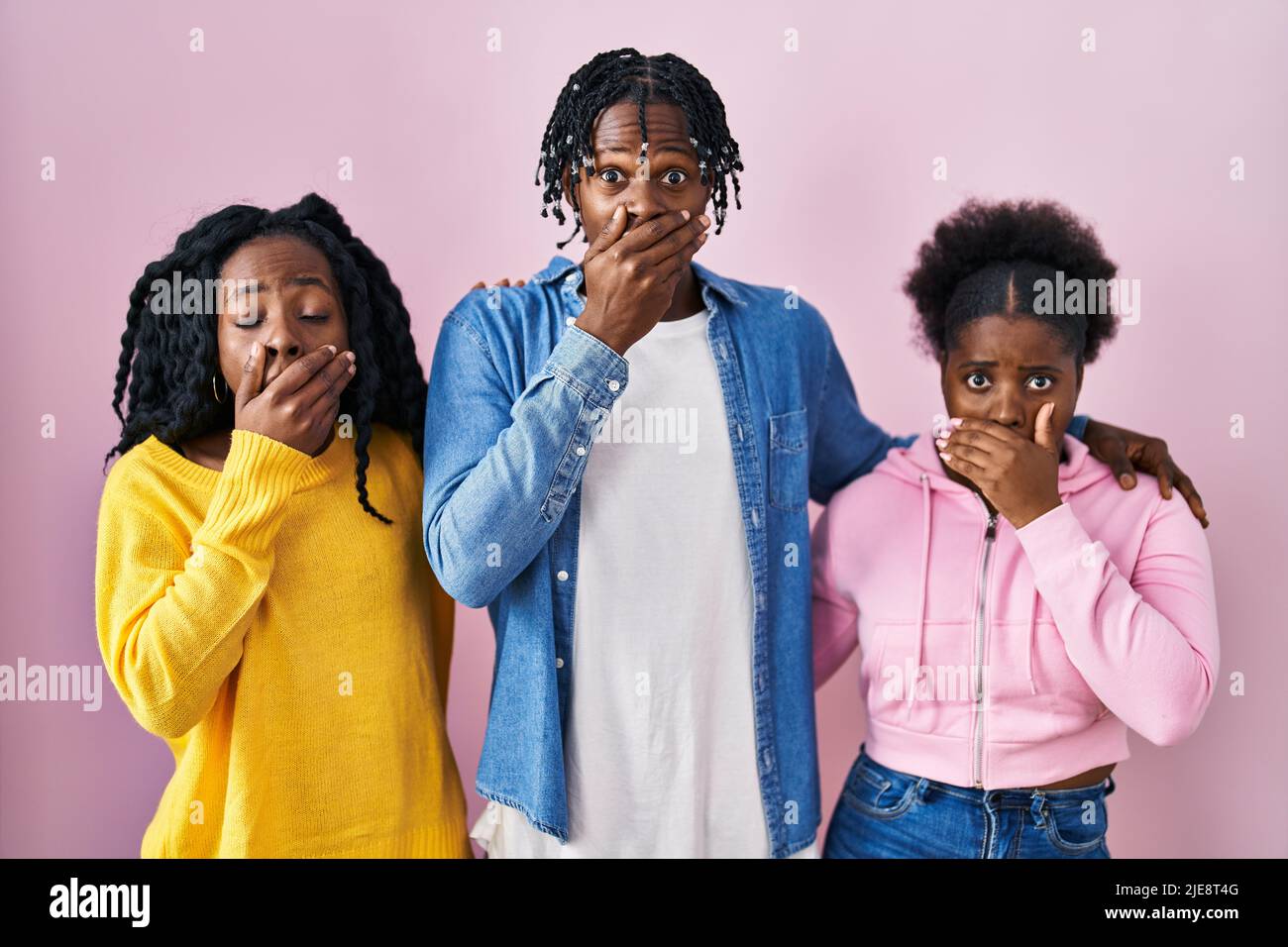 Group of three young black people standing together over pink ...