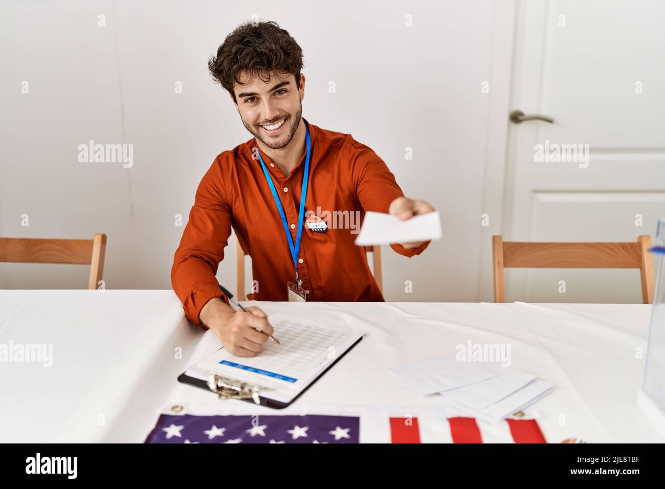Young hispanic man smiling confident holding vote and writing on ...