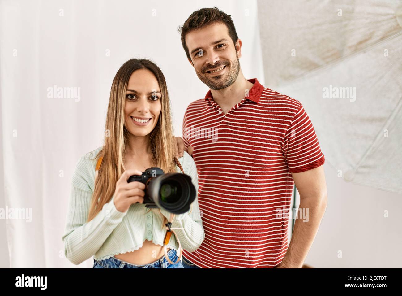 Professional photographer and model holding camera standing at ...