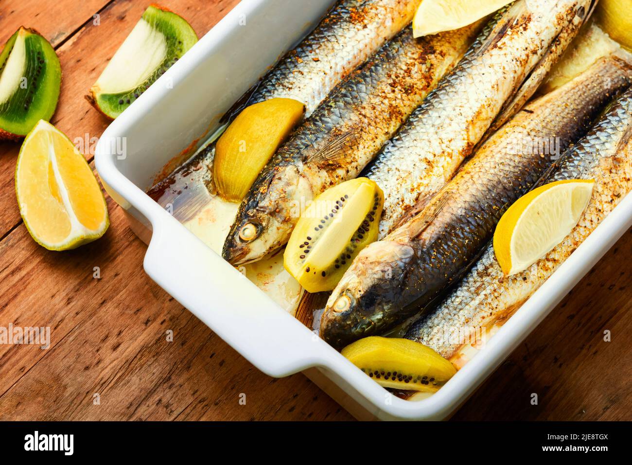 Delicious roasted pelengas, fish with kiwi and lime Stock Photo - Alamy