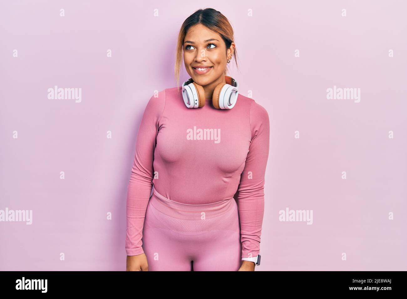 Beautiful Hispanic Woman Wearing Gym Clothes And Using Headphones