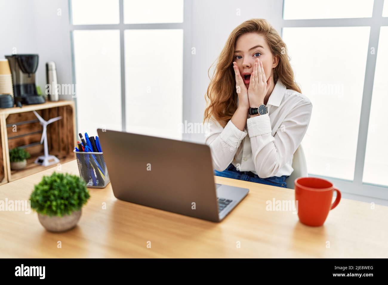 Young caucasian woman working at the office using computer laptop ...