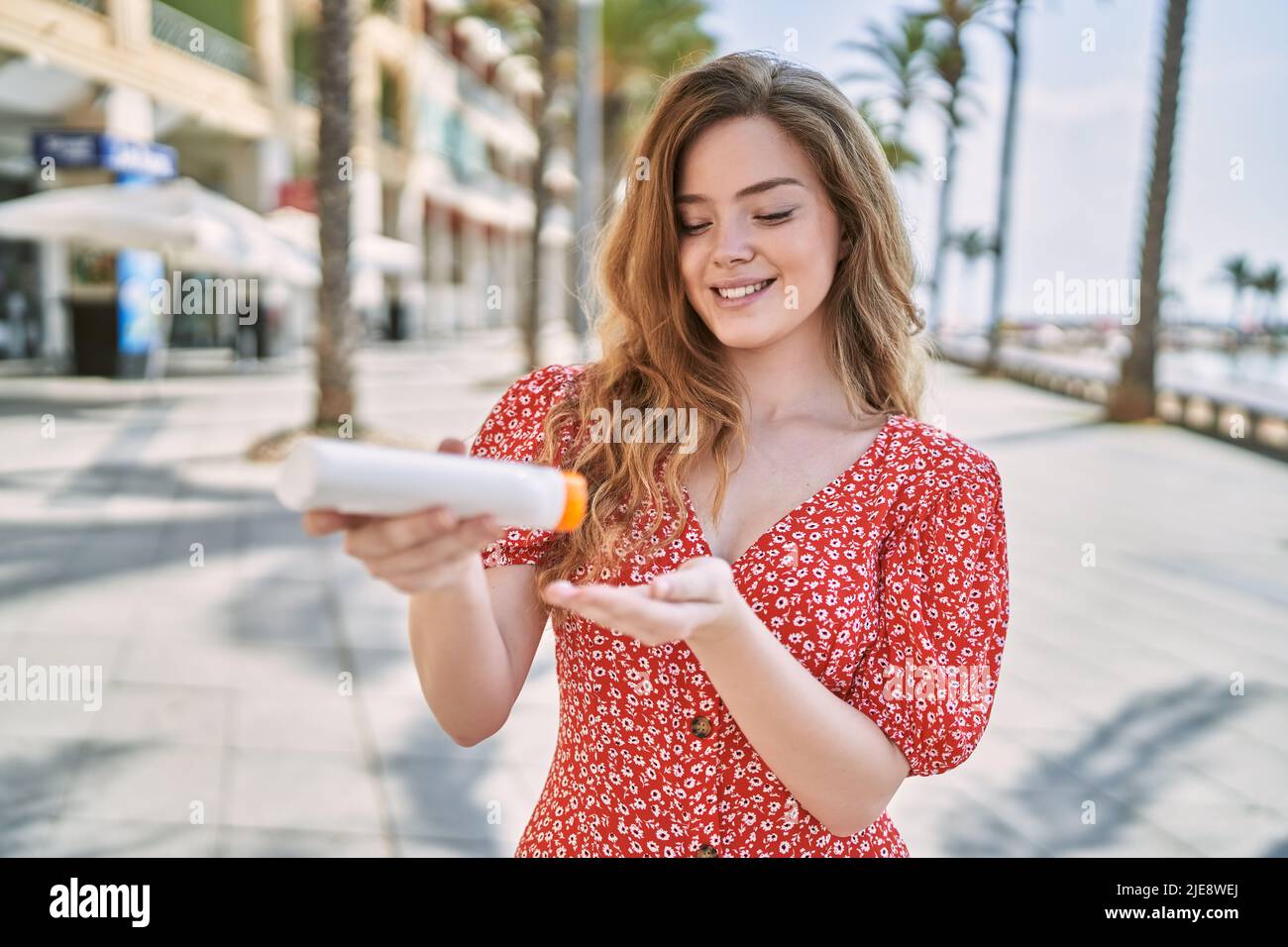 Young caucasian girl smiling confident using sunscreen at street Stock ...
