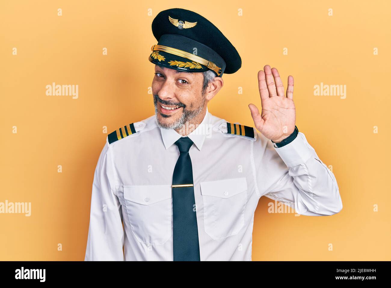 Handsome middle age man with grey hair wearing airplane pilot uniform ...