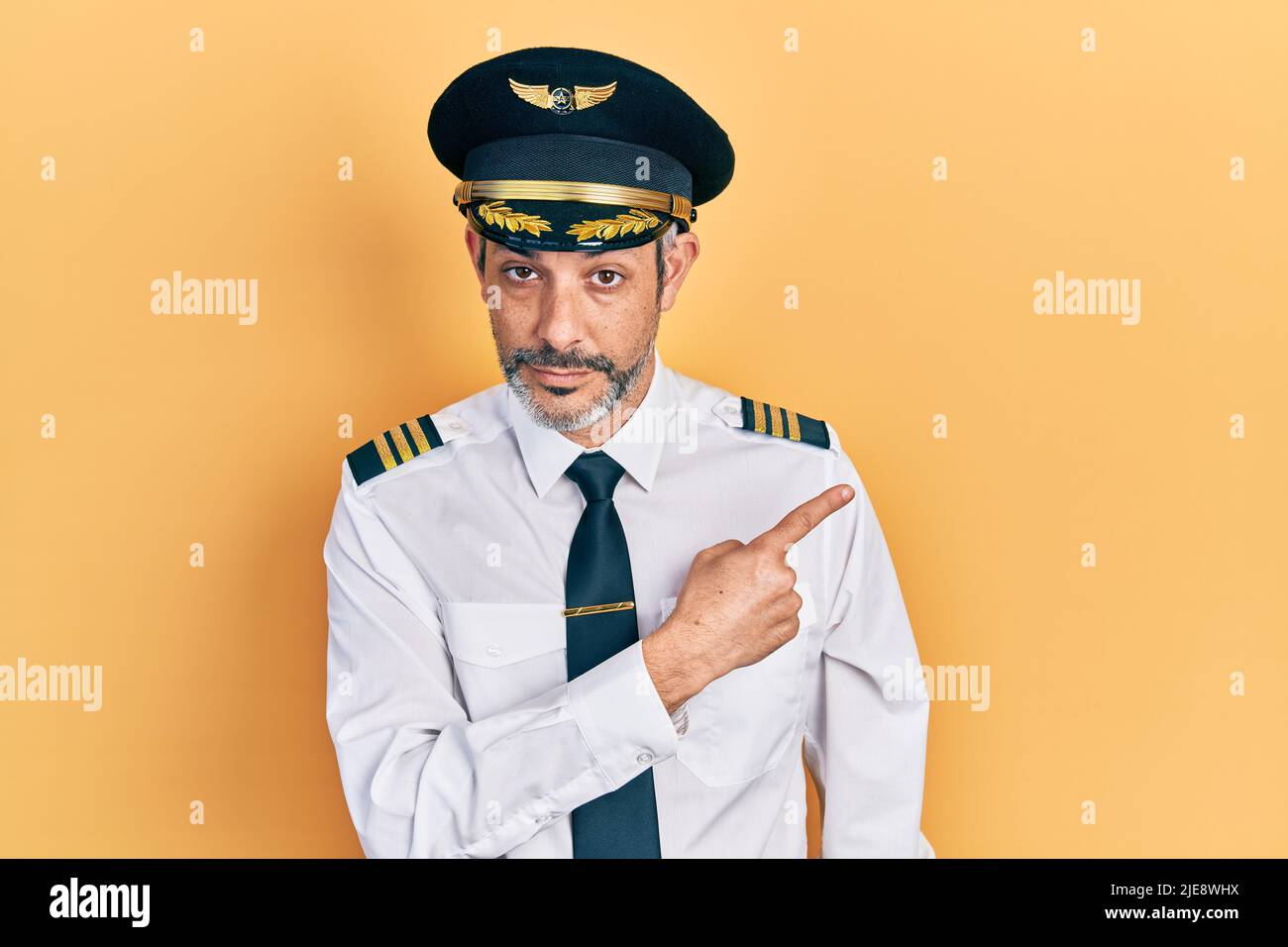 Handsome middle age man with grey hair wearing airplane pilot uniform ...
