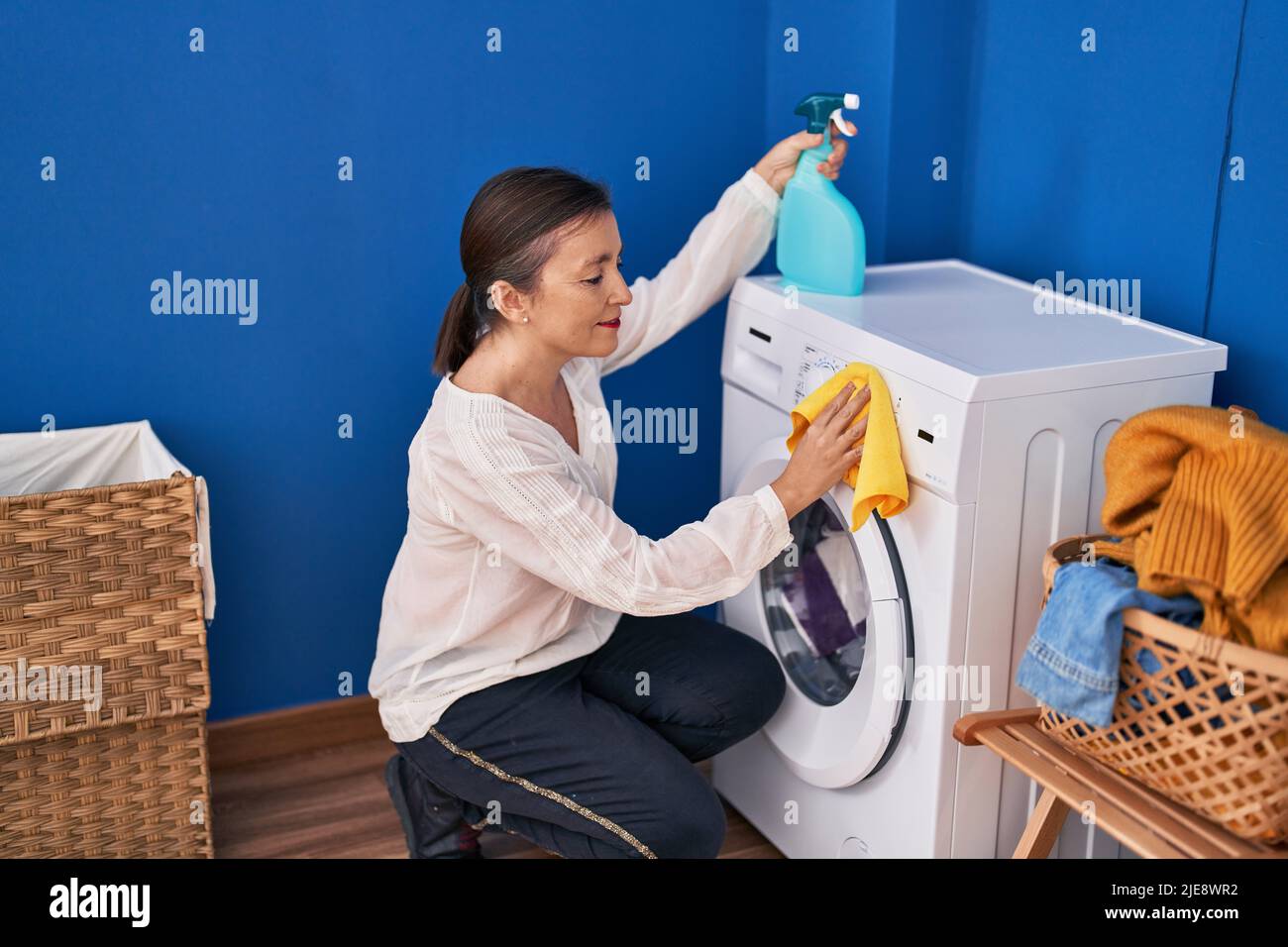 Middle age woman cleaning washing machine at laundry room Stock Photo ...