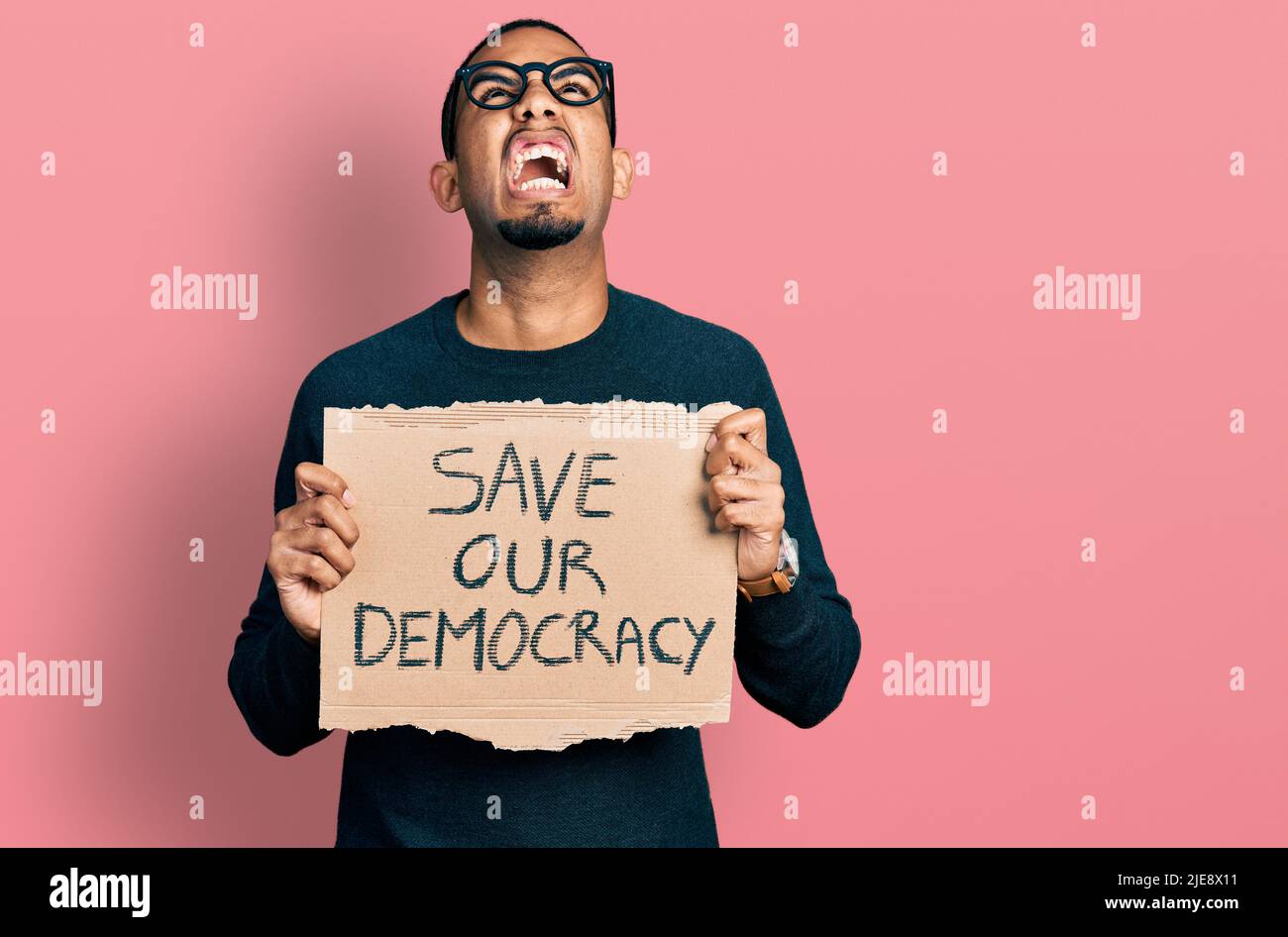 Young african american man holding save our democracy protest banner ...