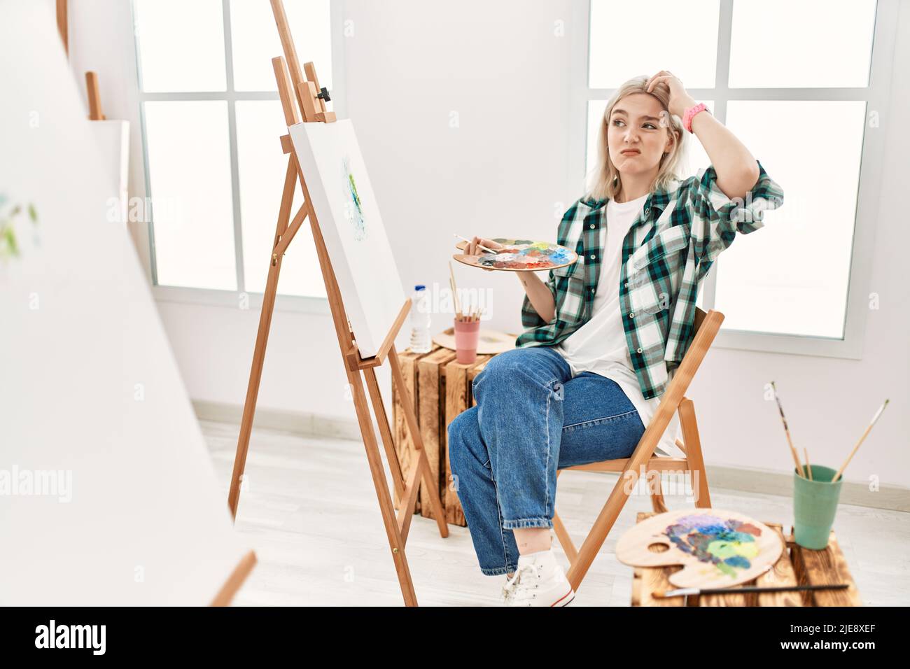 Young artist woman painting on canvas at art studio confuse and ...