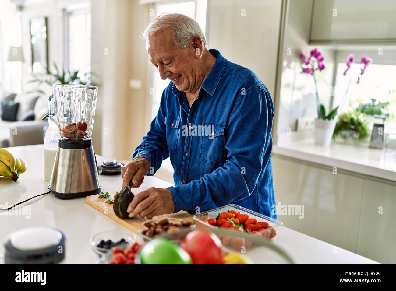 Senior man smiling confident cutting avocado at kitchen Stock Photo - Alamy
