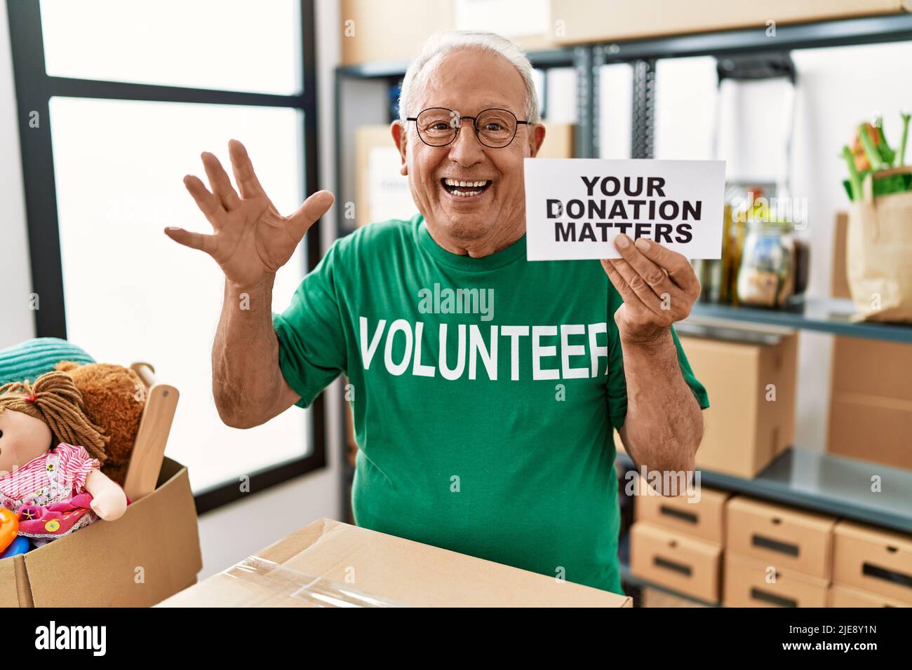 Senior volunteer man holding your donation matters celebrating victory ...