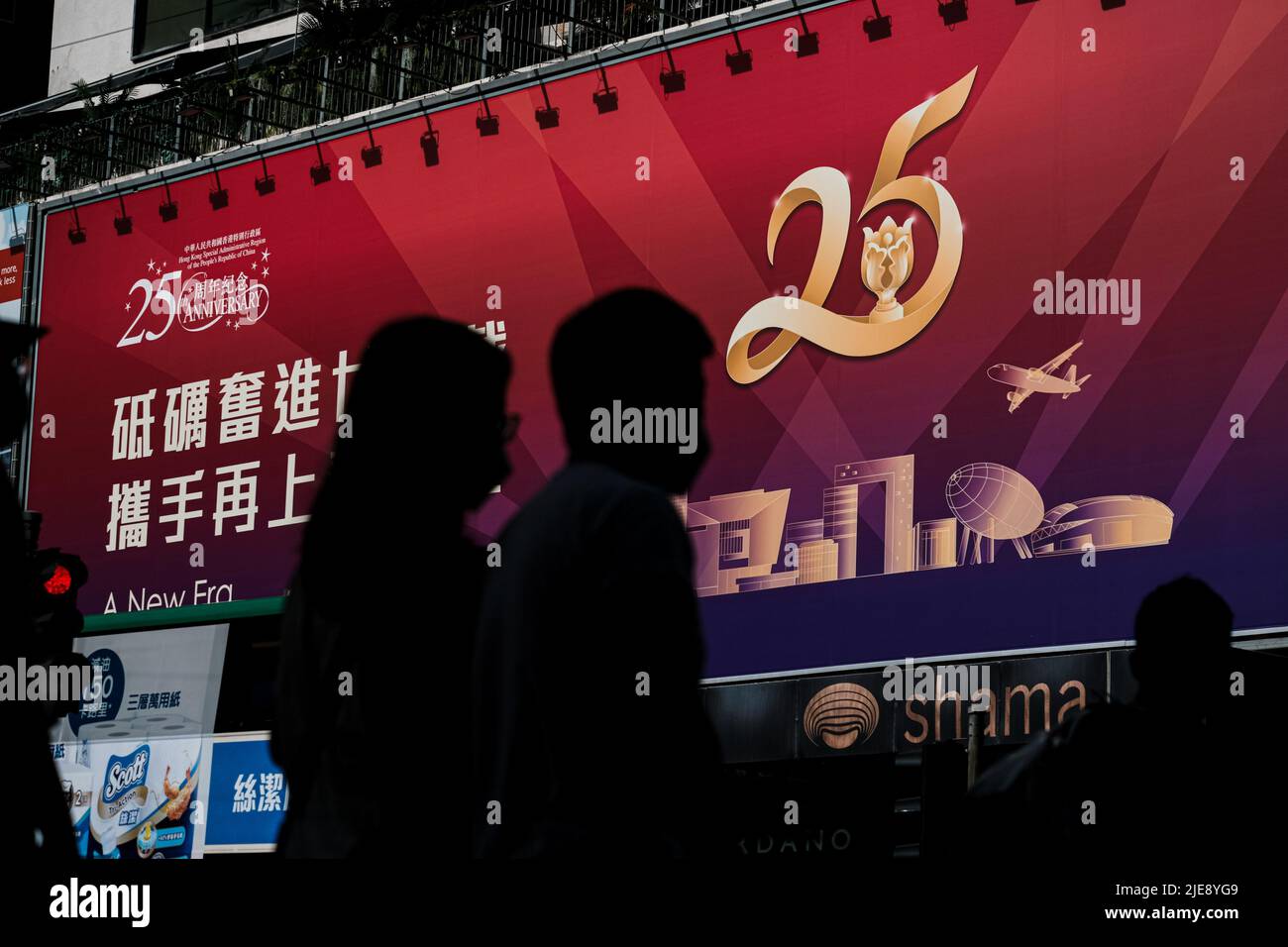 Hong Kong, China. 26th June, 2022. People walk in front of a large ...