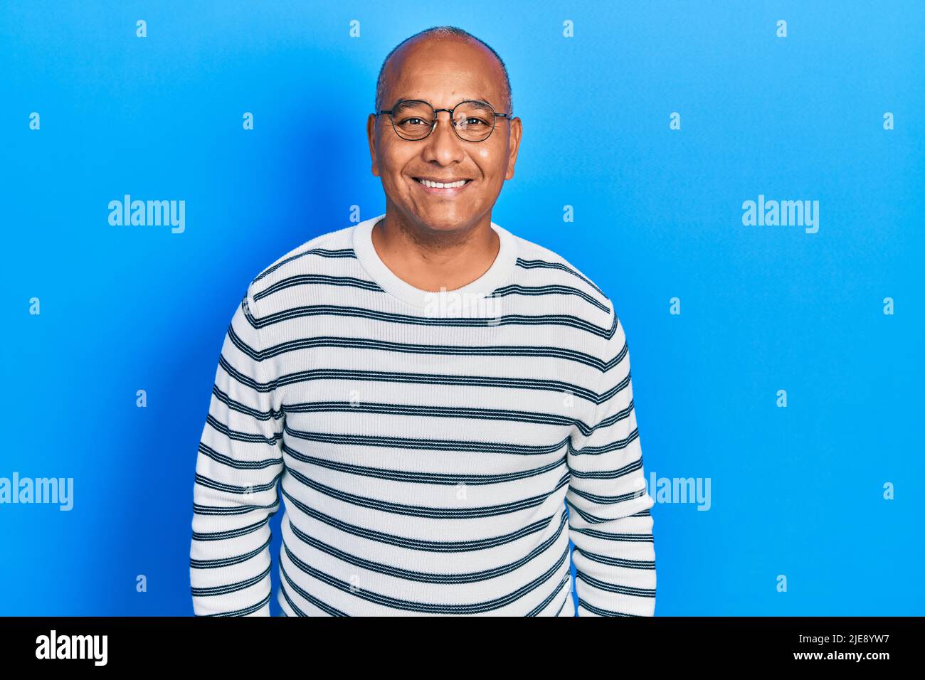 Middle age latin man wearing casual clothes and glasses with a happy ...