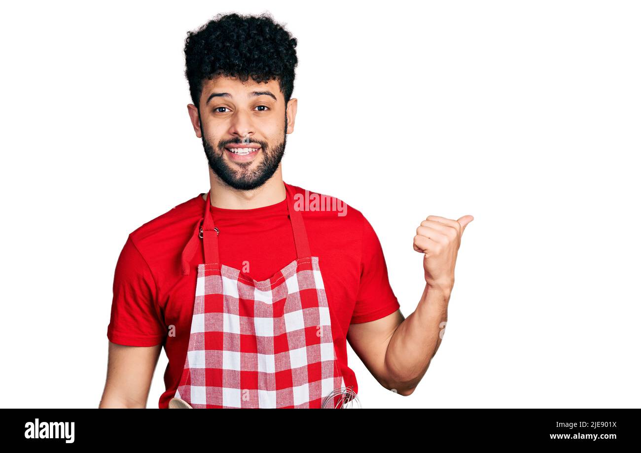 Young arab man with beard wearing cook apron smiling with happy face ...