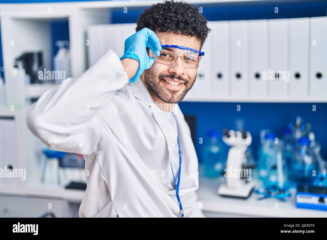 Young arab man wearing scientist uniform smiling confident at ...