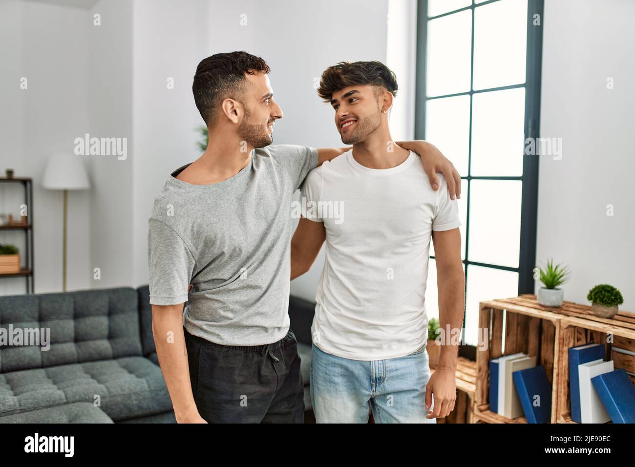 Two hispanic men couple smiling confident hugging each other at home ...