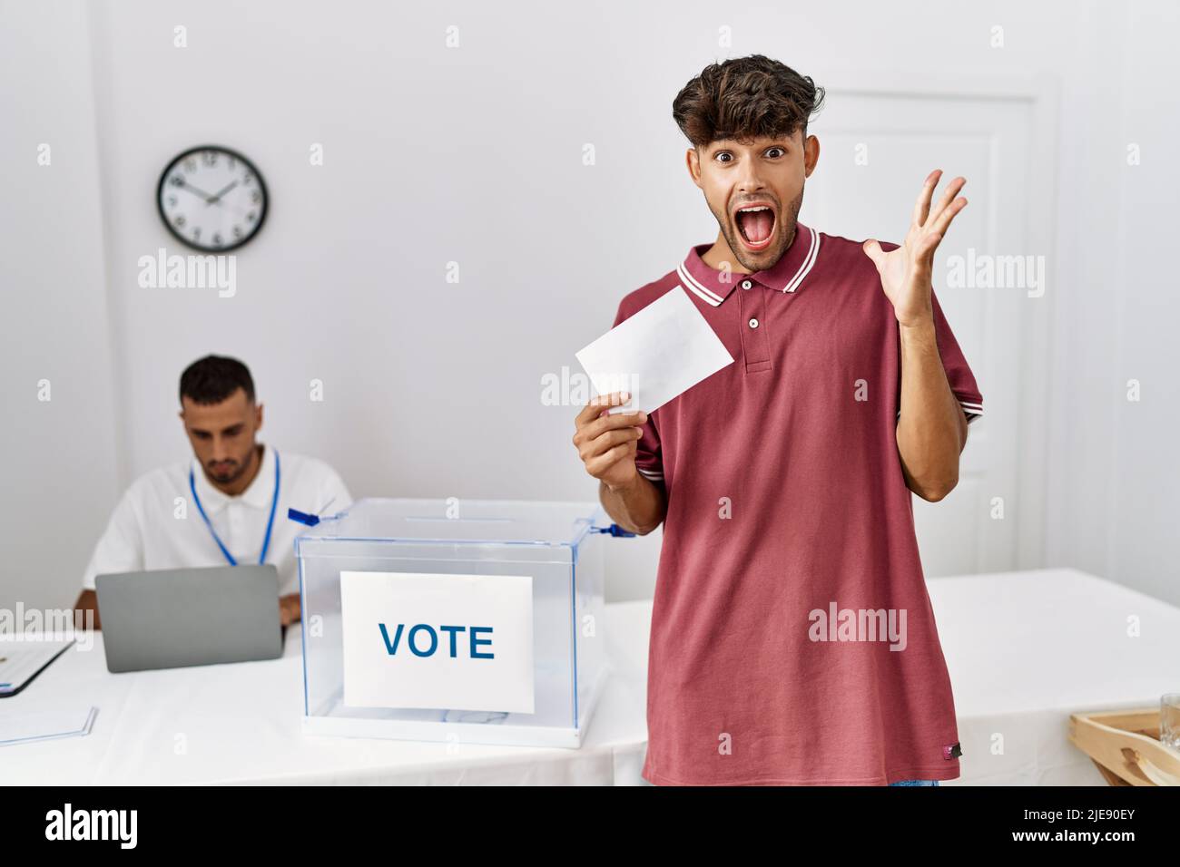 Young hispanic man voting putting envelop in ballot box celebrating ...