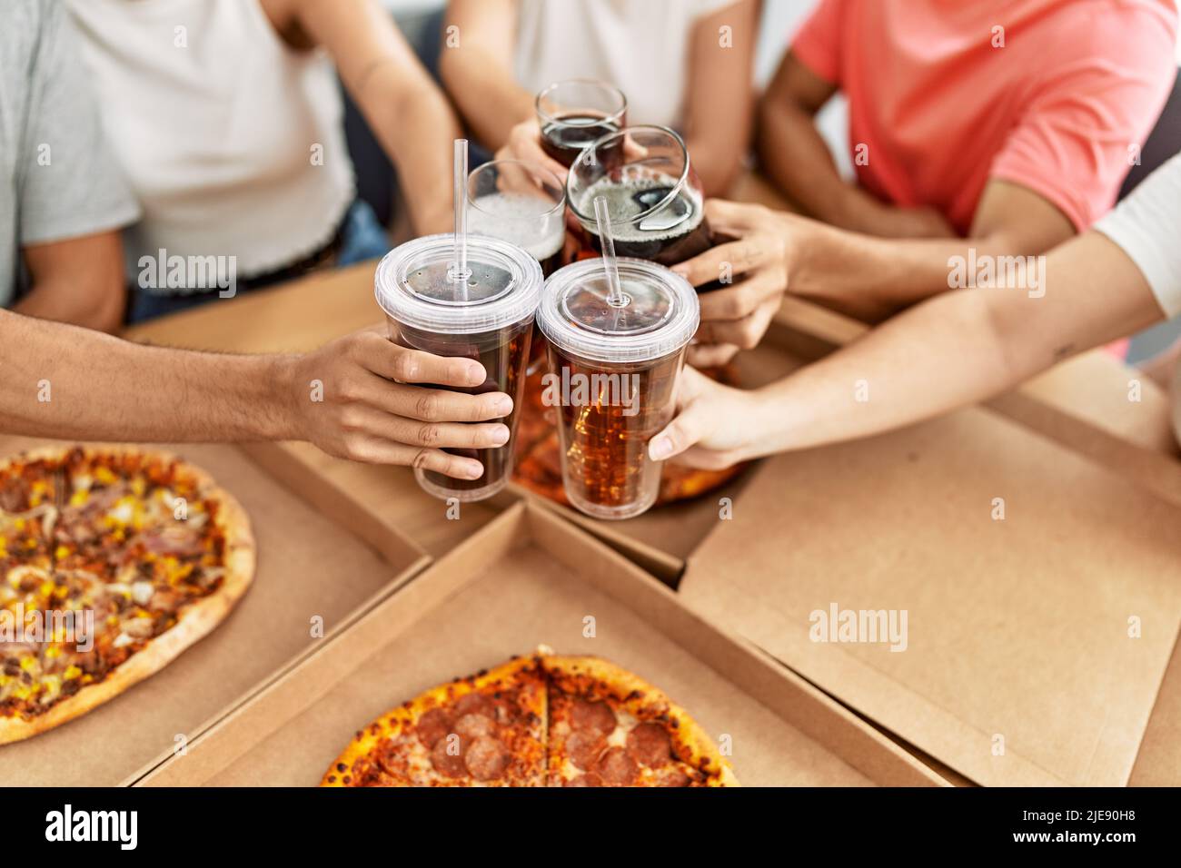 Group of young friends smiling happy eating italian pizza and toasting ...