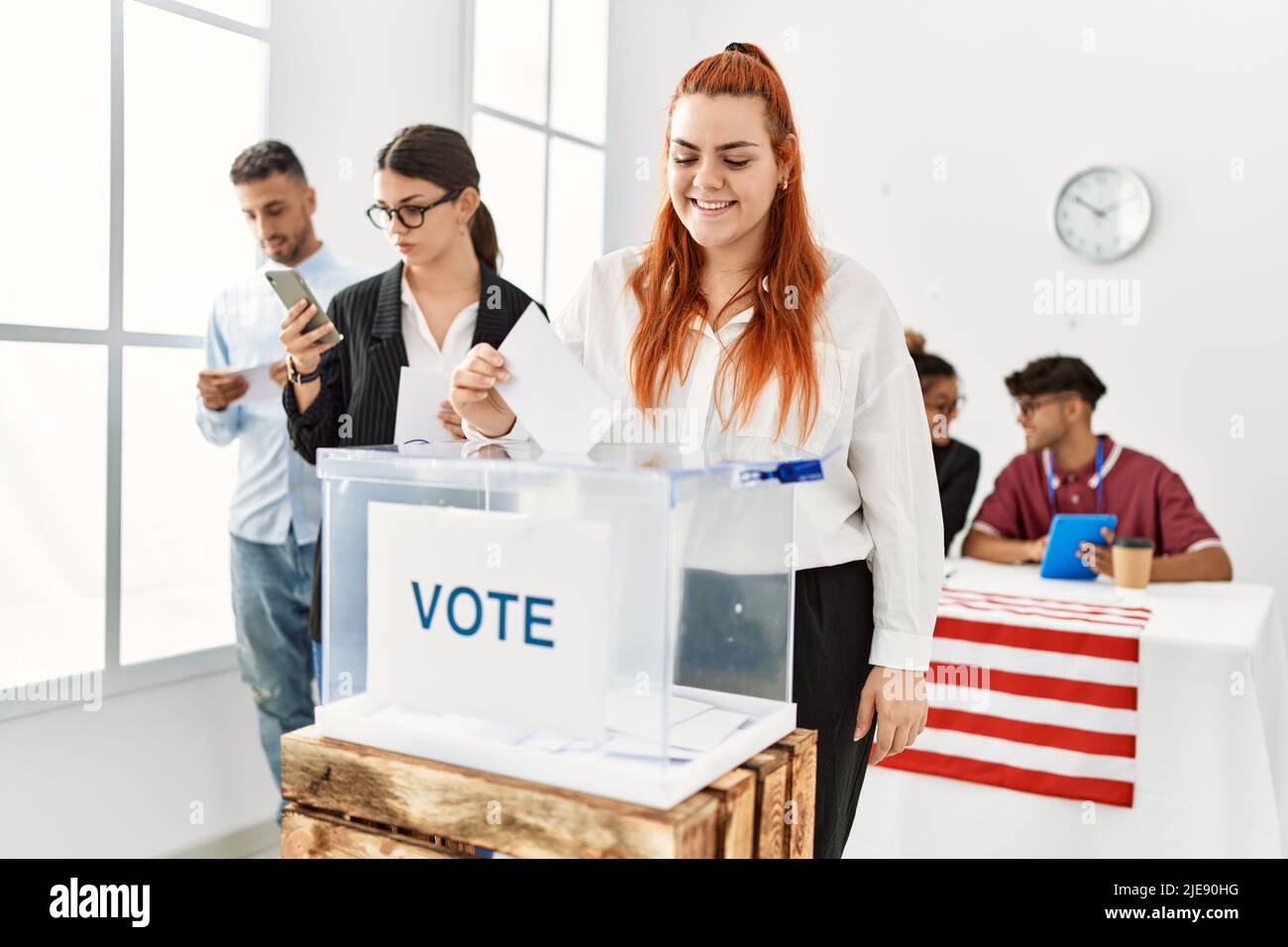 Young american voter woman smiling happy putting ballot in voting box ...